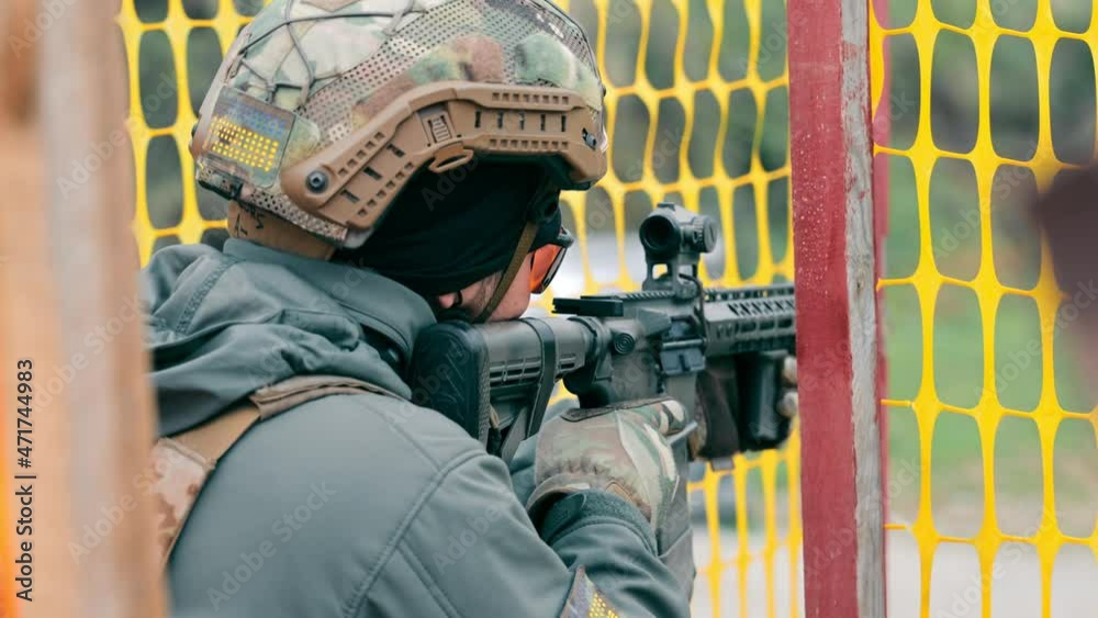 military shoots with a machine gun close up. A fighter of the American ...