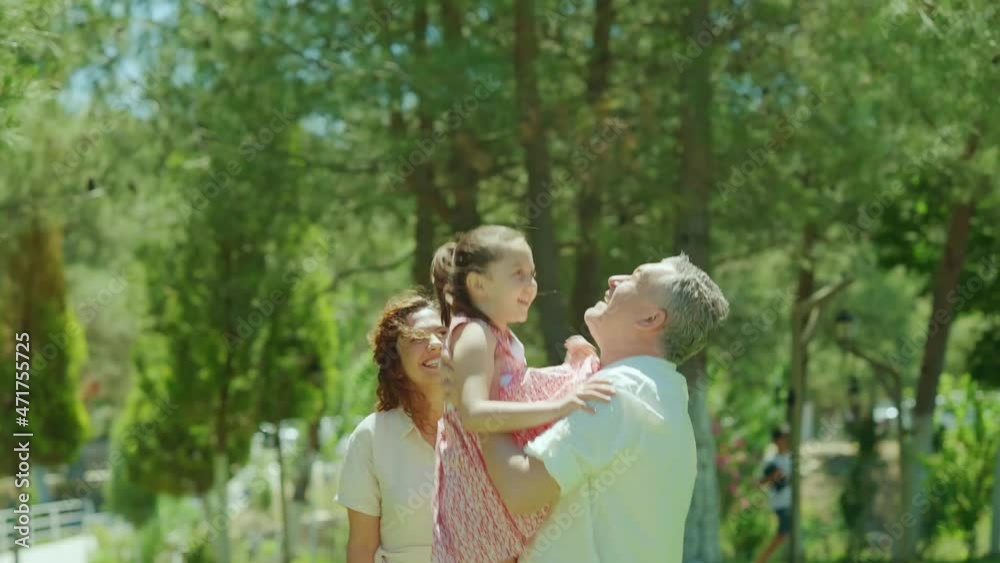Cute little girl running with open arms on green grass. The father ...