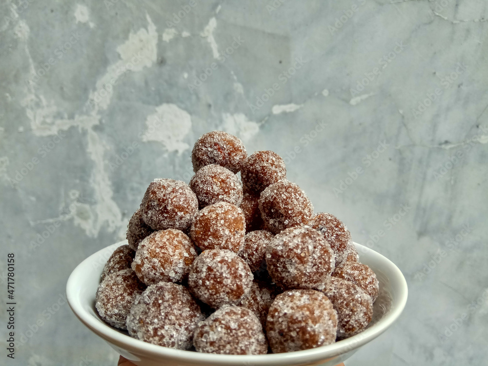 Tamarind candy, placed inside white small plate. Sweet and sour candy ...