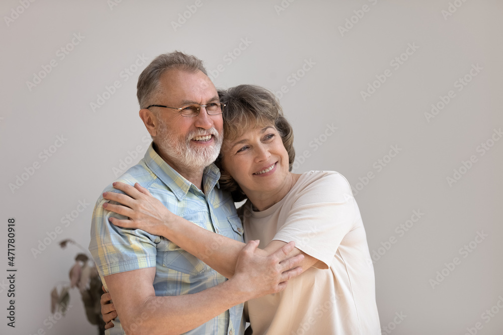 Cheerful dreamy older 60s married couple hugging with love, care ...