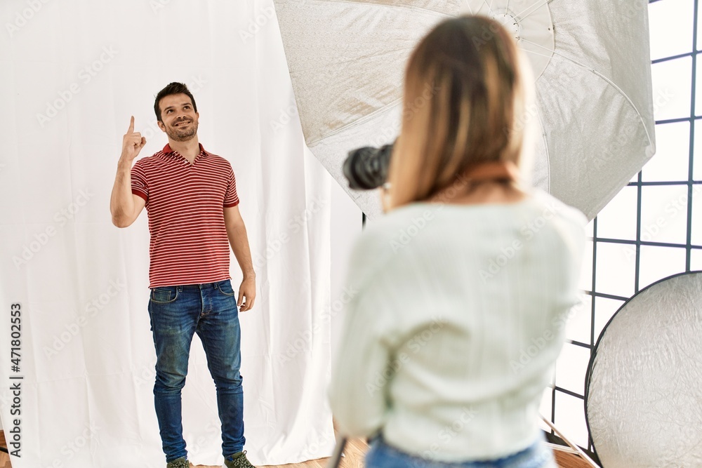Woman photographer talking pictures of man posing as model at ...