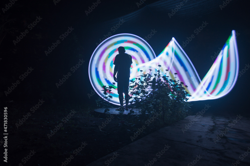 One person standing alone against beautiful color circle LED light ...