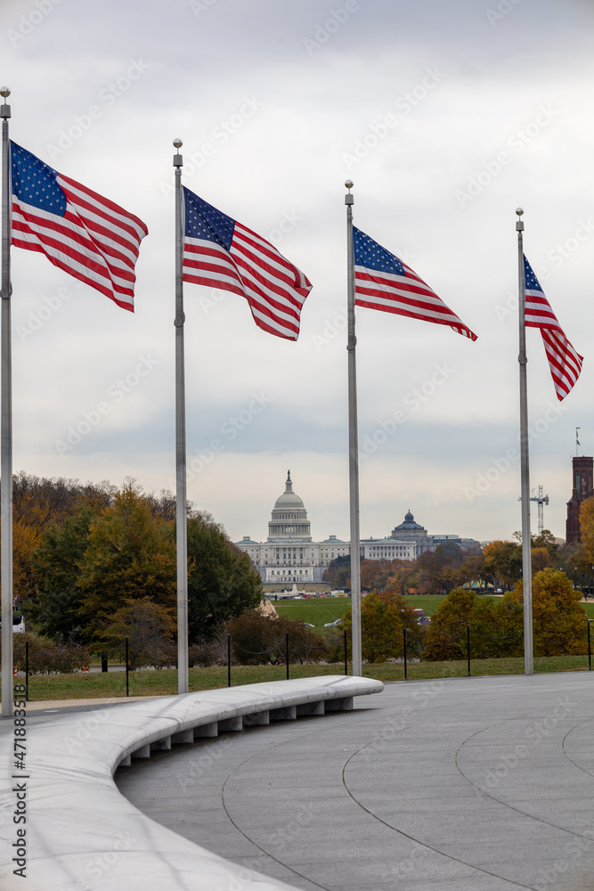 Four American flags with stone and marble foreground. Capitol building ...