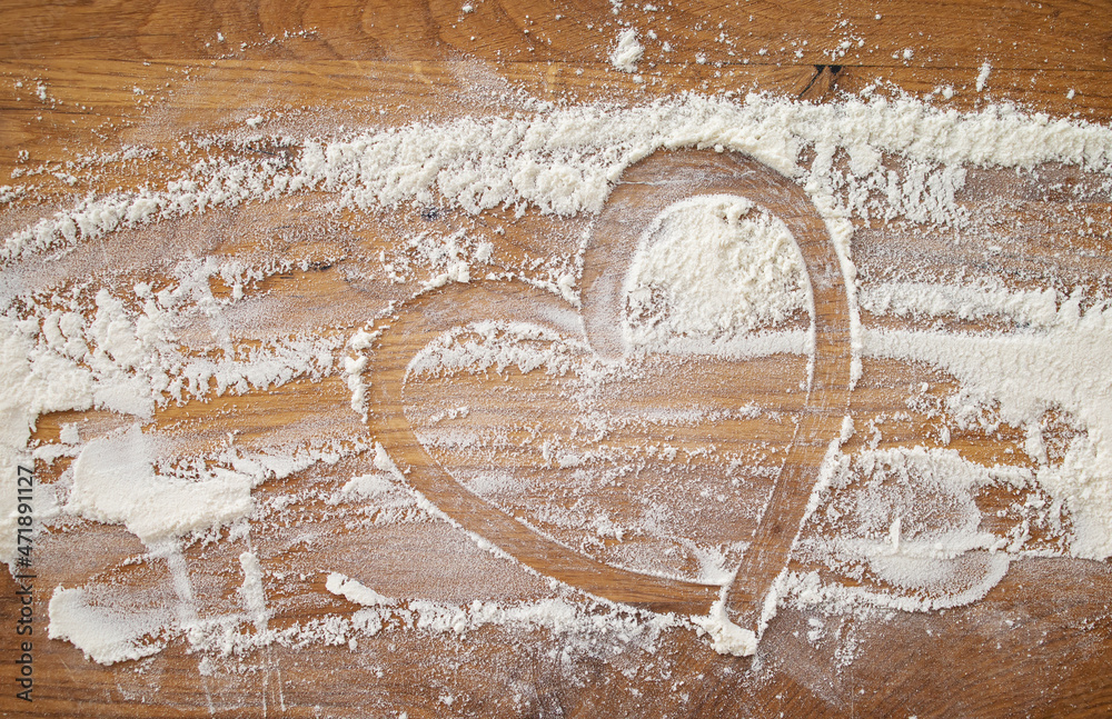 white flour on table. Baking background with heart shape and flour on a ...