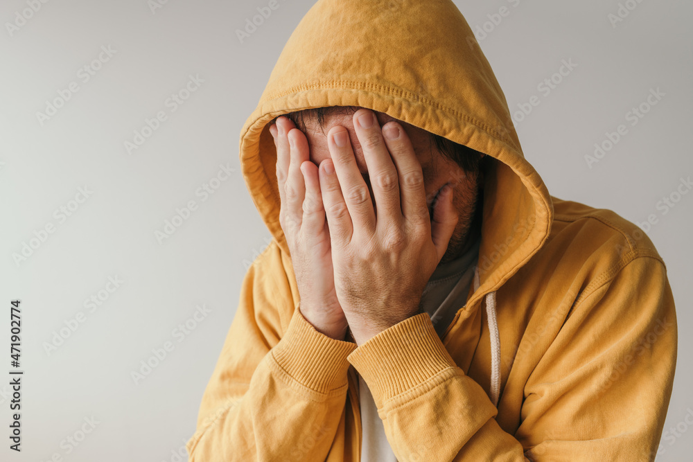 Casual sad man in yellow hoodie is crying in emotional breakdown ...