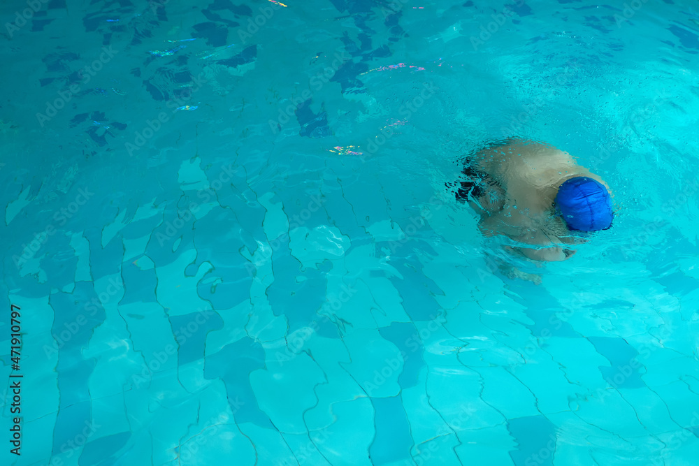 Child swimming training in a swimming pool. float exercise for buoyancy ...