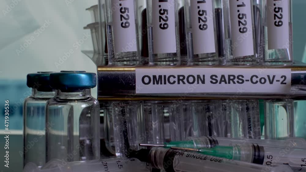 Close up pan shot of test tubes labelled Omicron in a research ...