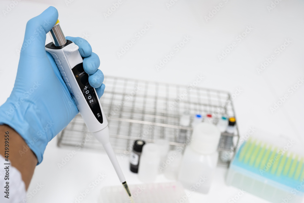 Blue glove scientist hand holding pipette for taking laboratory ...