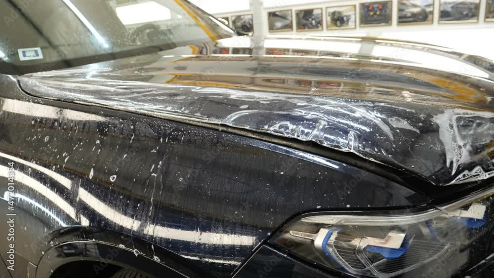 Close up to PPF installation process on a front headlight and hood. PPF ...
