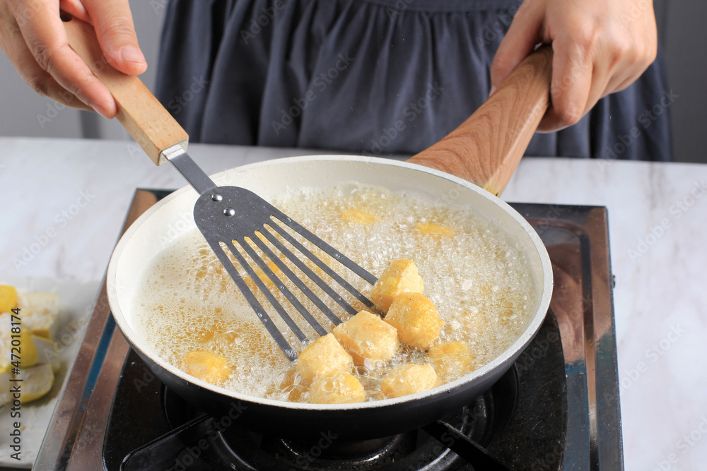 Asian House Wife Frying Tofu on Hot Oil, Using Gas Stove in the Kitchen ...