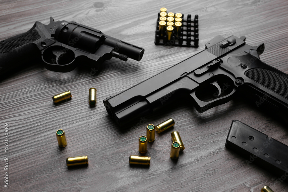 Pistols and bullets on wooden table. Professional guns Stock Photo ...