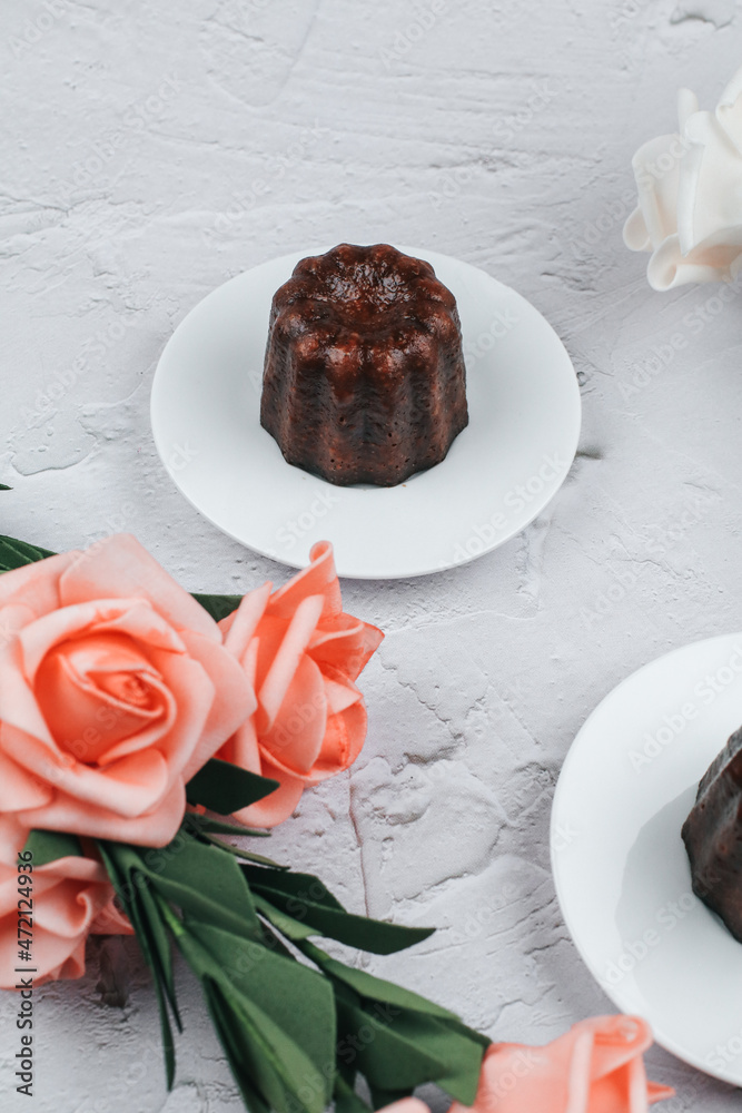 Caneles de bordeaux with rose traditional French sweet dessert on white ...