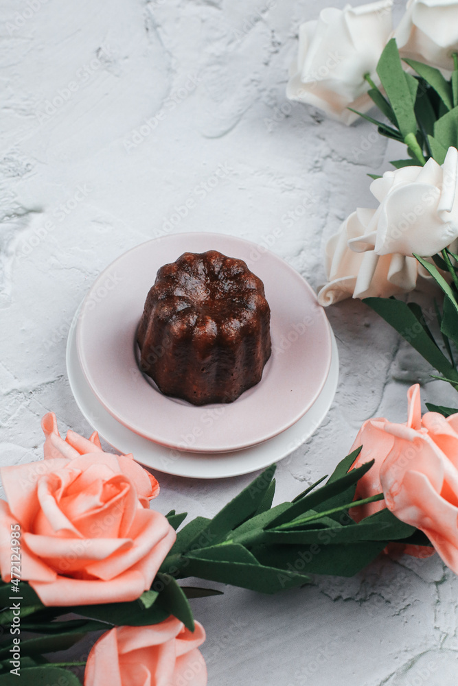 Caneles de bordeaux with rose traditional French sweet dessert on white ...