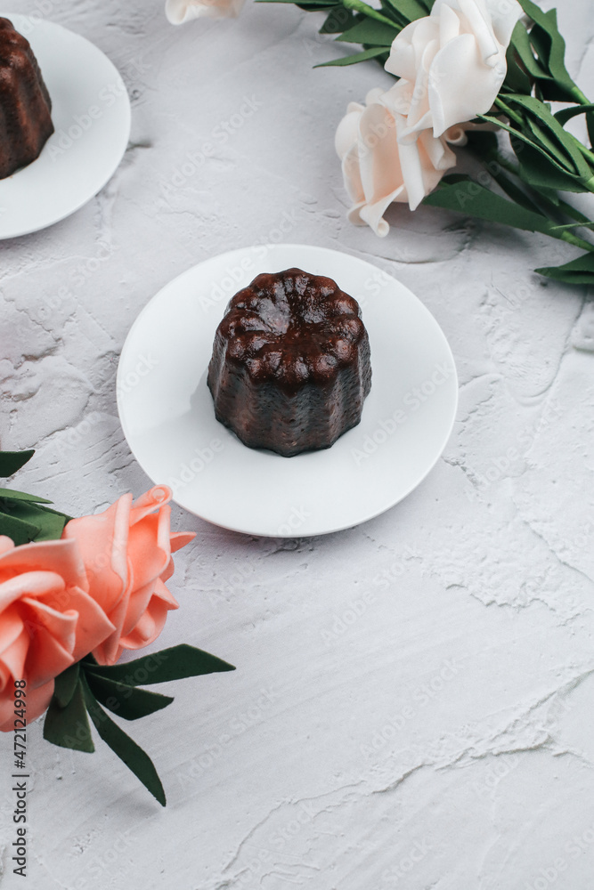 Caneles de bordeaux with rose traditional French sweet dessert on white ...