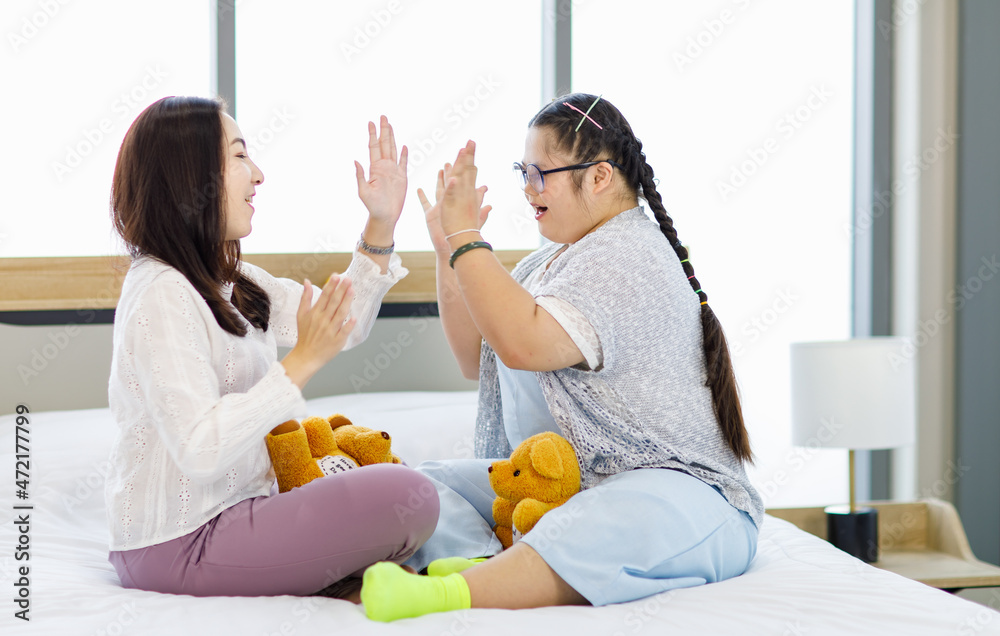 Asian lovely mother sitting on bed in bedroom smiling laughing playing ...