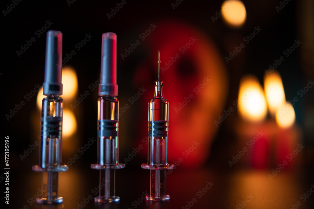 Medical syringes evil skull on a black background. Vaccination against ...