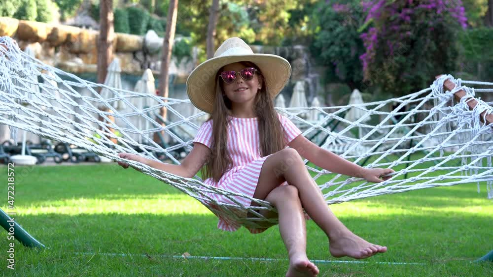 Happy beach vacation little girl relaxing lying down on outdoor patio ...
