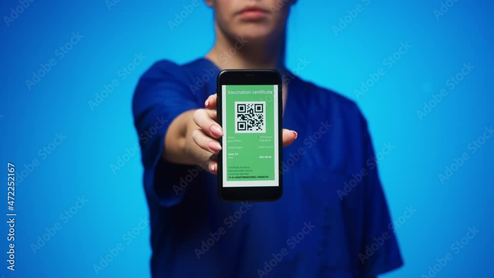 Woman surgeon in medical uniform showing vaccination passport with qr ...