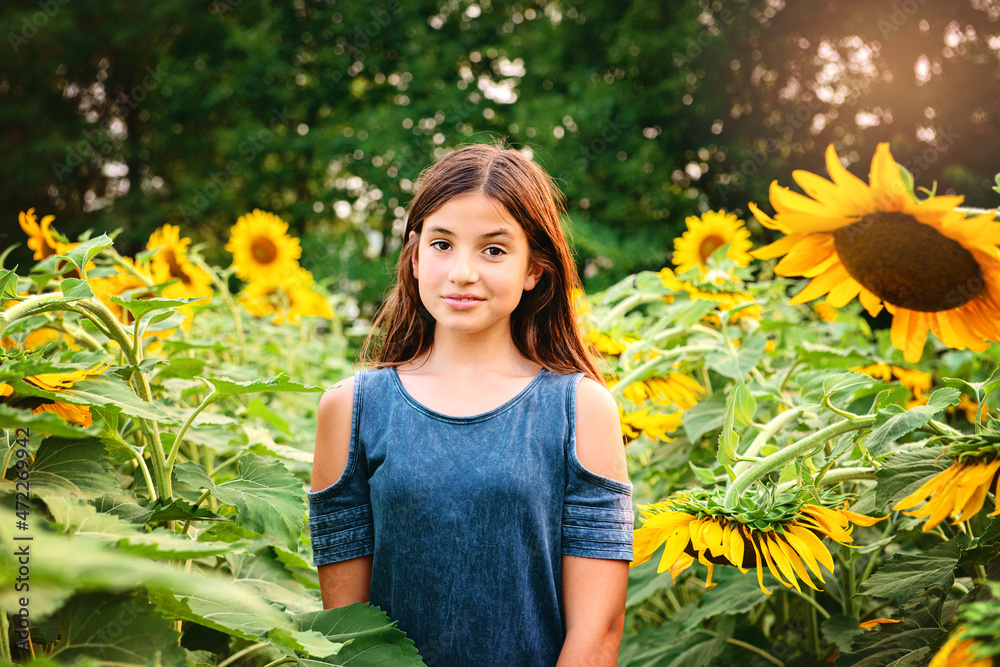 Happy tween girl in a sunflower field. Stock Photo | Adobe Stock