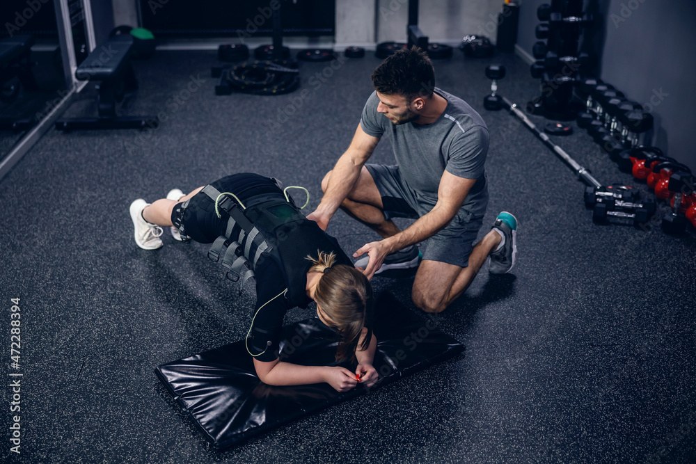 EMS training studio. Shot from above of a female athlete wearing an EMS ...