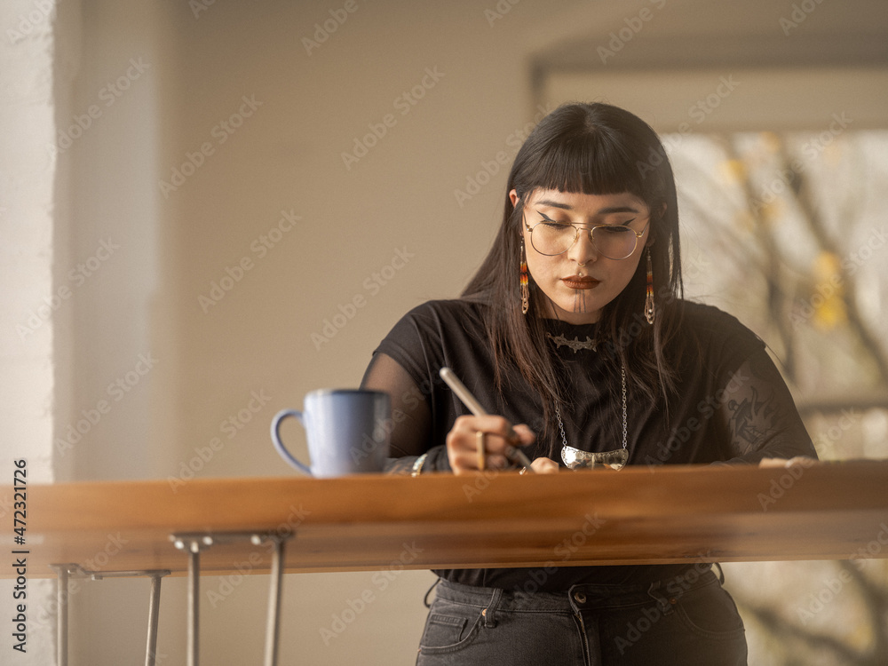Non binary Indigenous artist drawing indoors Stock Photo | Adobe Stock