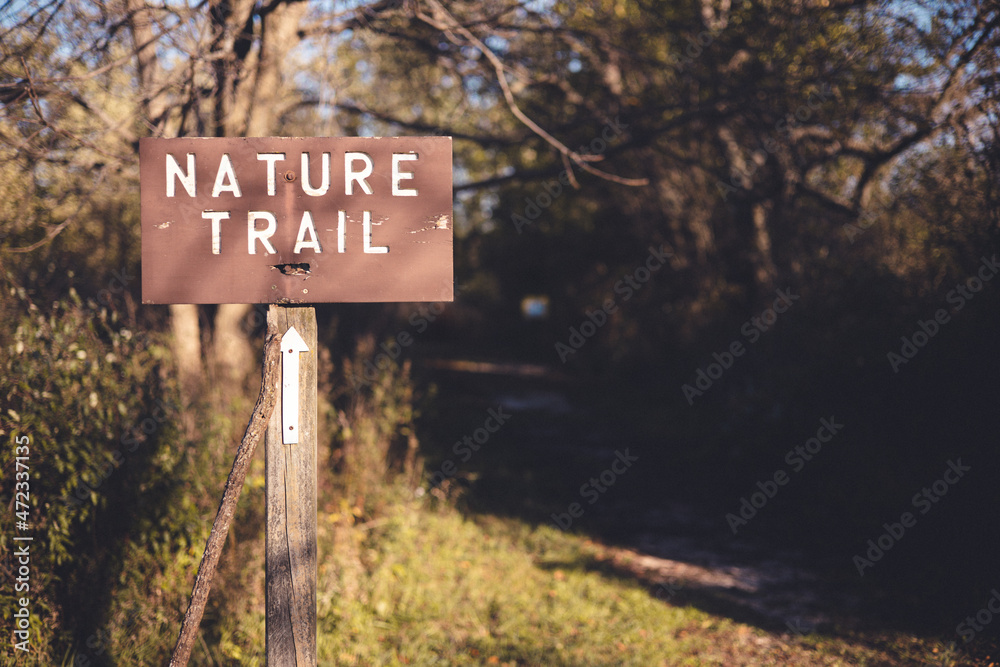 Wooden sign marking trail name on a wooden post. Arrow marking which ...