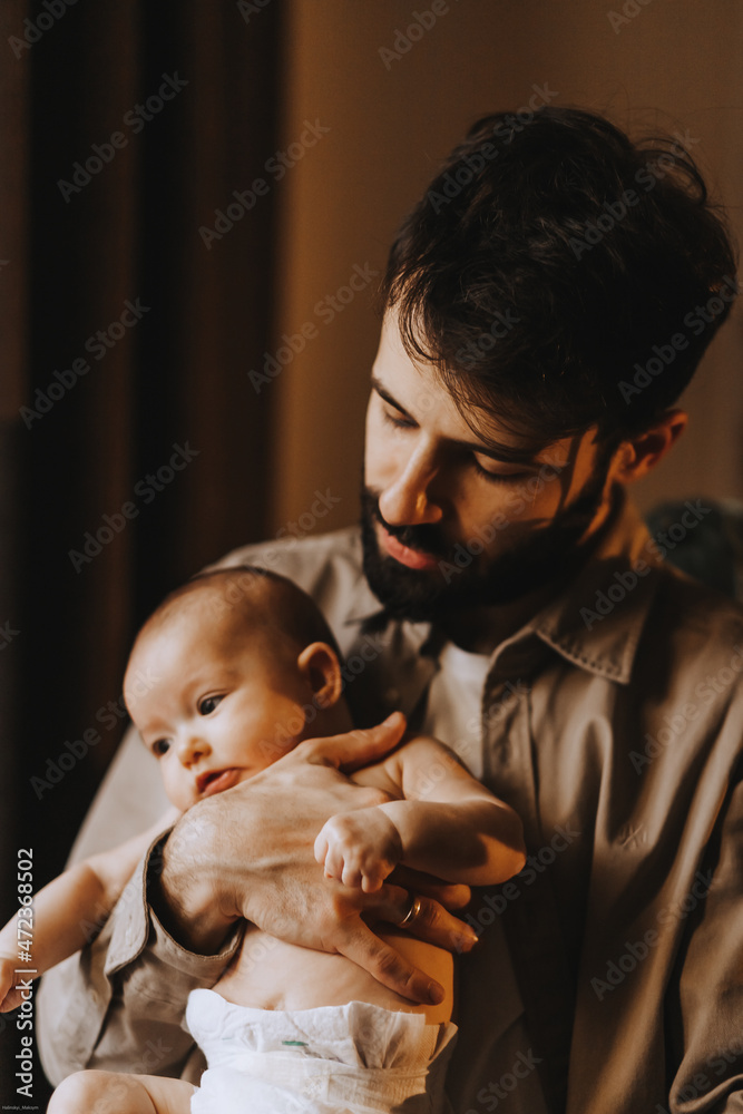 Stylish Caucasian bearded father carrying newborn baby on shoulder ...