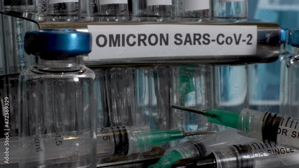 A close look on a metal tube rack labeled OMICRON SARS-CoV-2. A metal ...