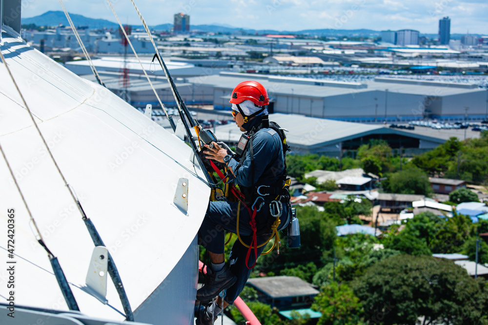 Male workers control rope down top roof tank rope access inspection of ...