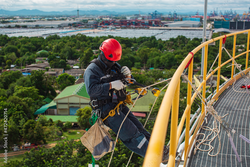 Focus top view male worker down height tank roof rope access safety ...