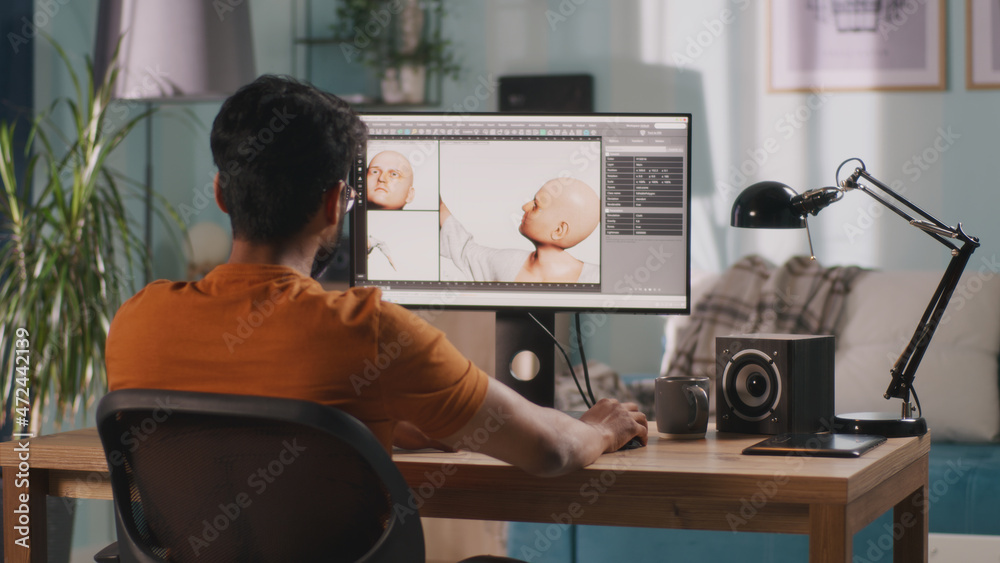 Back view of anonymous man creating 3D model of videogame character ...