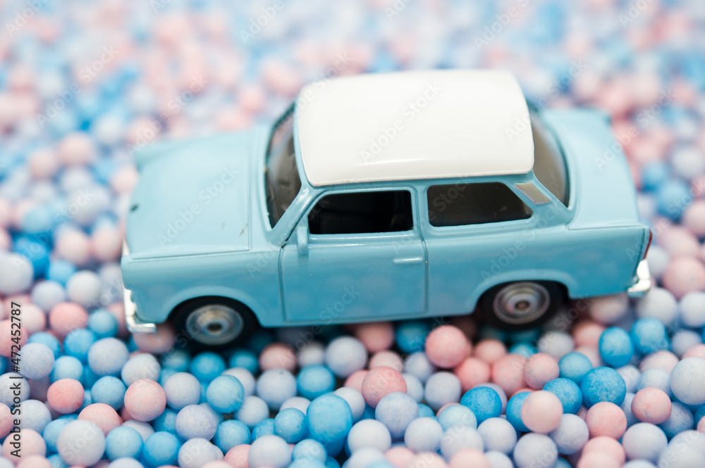 retro blue toy car over a background of micro spheres in pastels colors ...
