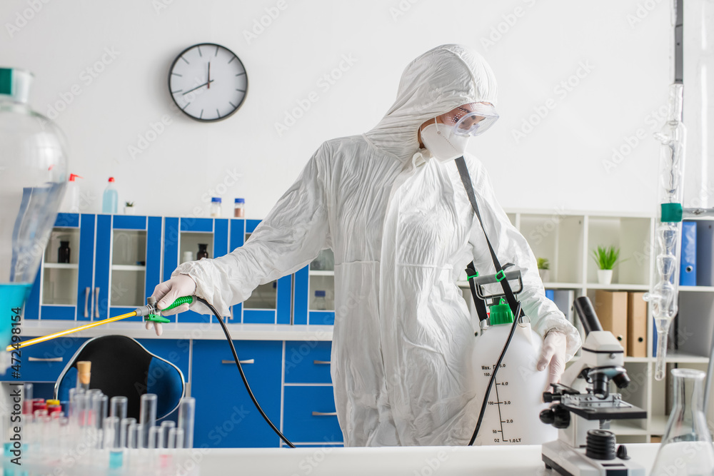 scientist in hazmat suit making disinfection of laboratory near ...