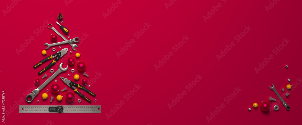 A symbolic Christmas tree made of construction tools on a blue ...