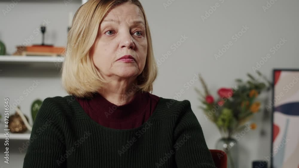 Blind woman reading braille book using fingers, sitting in living room ...