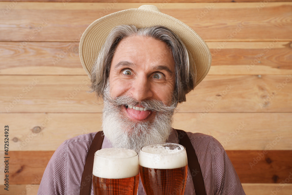 Funny man in traditional German clothes and with beer on wooden ...