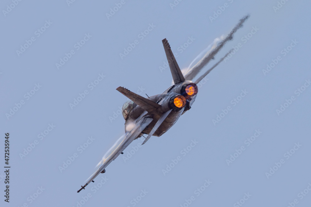 Tail view of a F-18 Hornet in a high G maneuver, with condensation ...