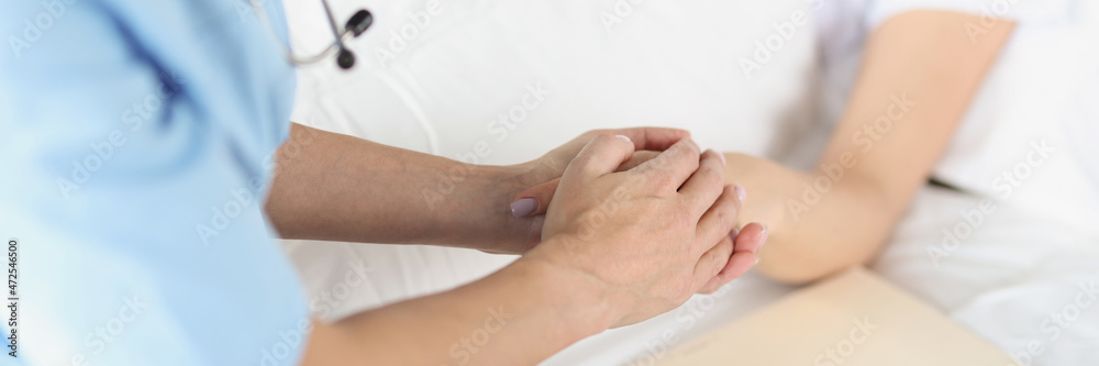 Female doctor hand holds hands of lying patient in hospital Stock Photo ...