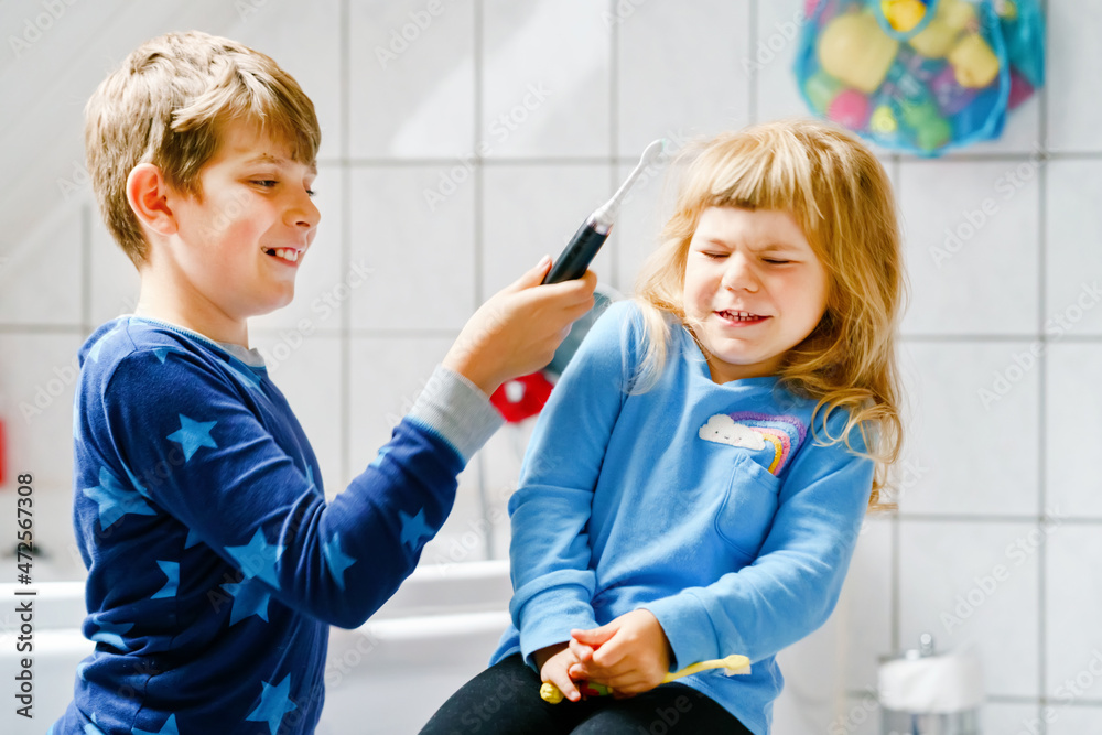 Little preschool girl and preteen school boy brushing teeth. Brother ...