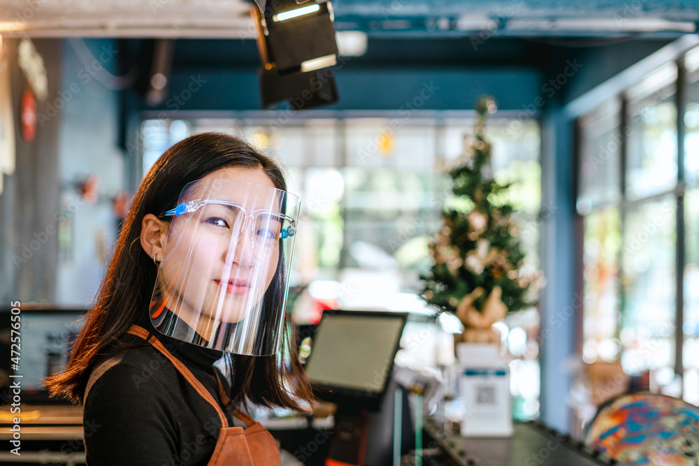 Young Asian adult owner gen z woman is wearing protective face shield ...