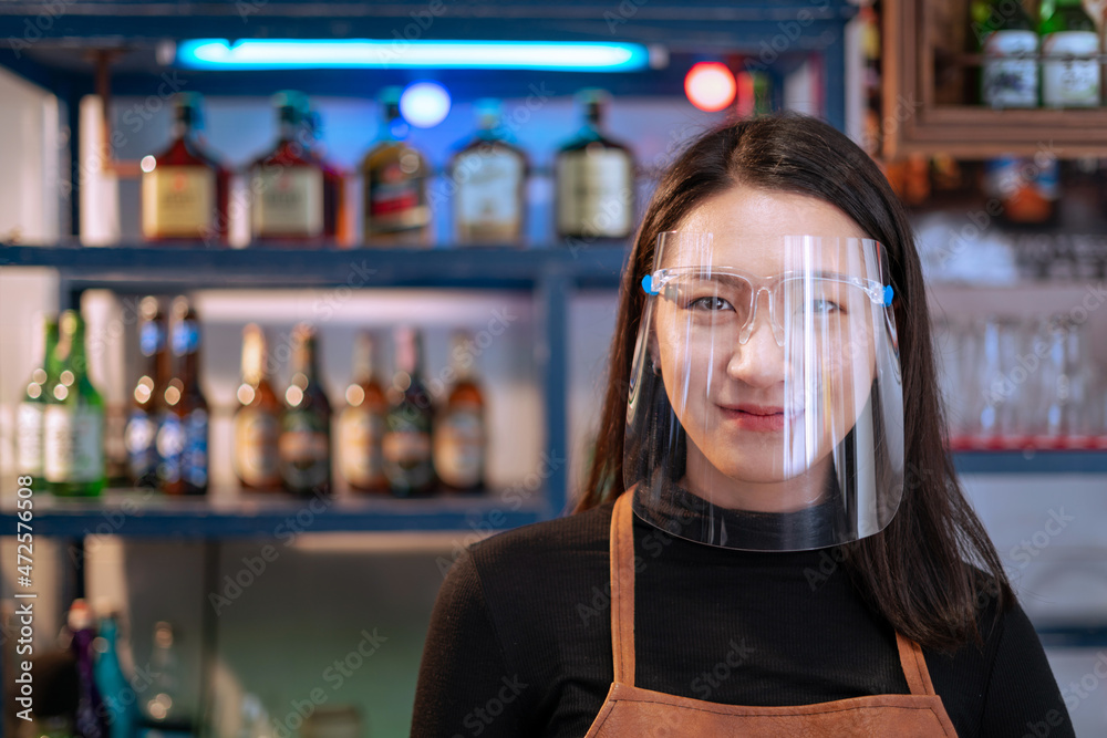 Asian adult owner gen z young woman is wearing protective face shield ...