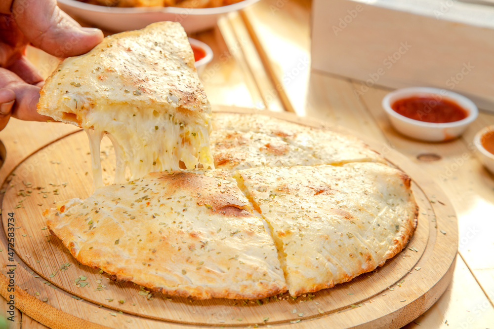 Hand pulling cheese of a very cheesy stuffed flat bread naan Stock ...