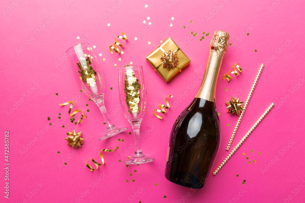 Bottle of champagne with colored glitter, confetti and gift box space ...