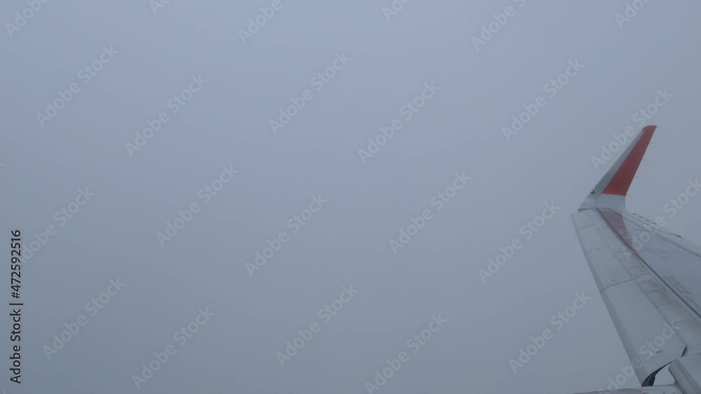airplane wing in dense fog. View of the thick fog from the plane's ...