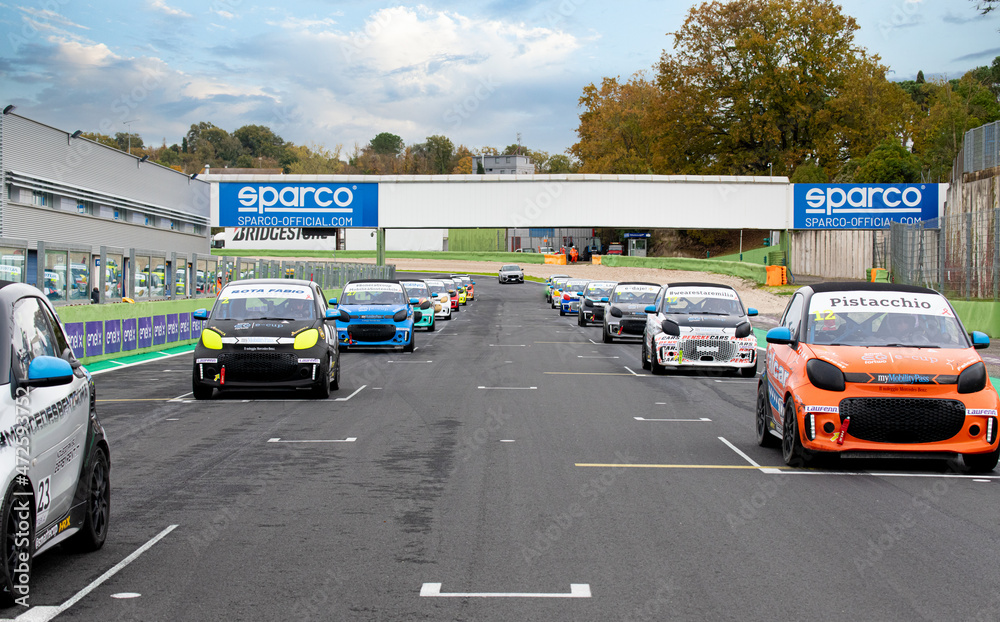 Car race starting grid, large number of electric Smart cars on straight ...