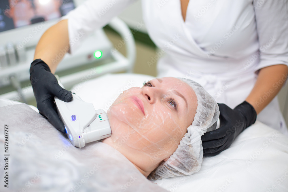 A woman in a cosmetology office receives a SMAS lifting procedure. Non ...