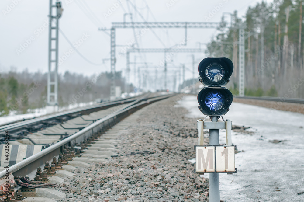 Dwarf traffic light with blue stop sign on railway station, railroad ...