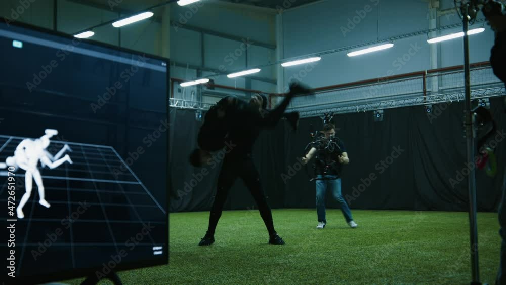 Cameraman filming actors performing some fight moves wearing motion ...