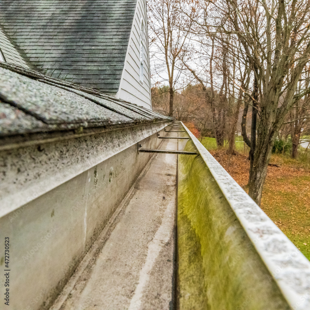 Cloudy day with a drizzel cleaning gutters close up view of the gutter ...