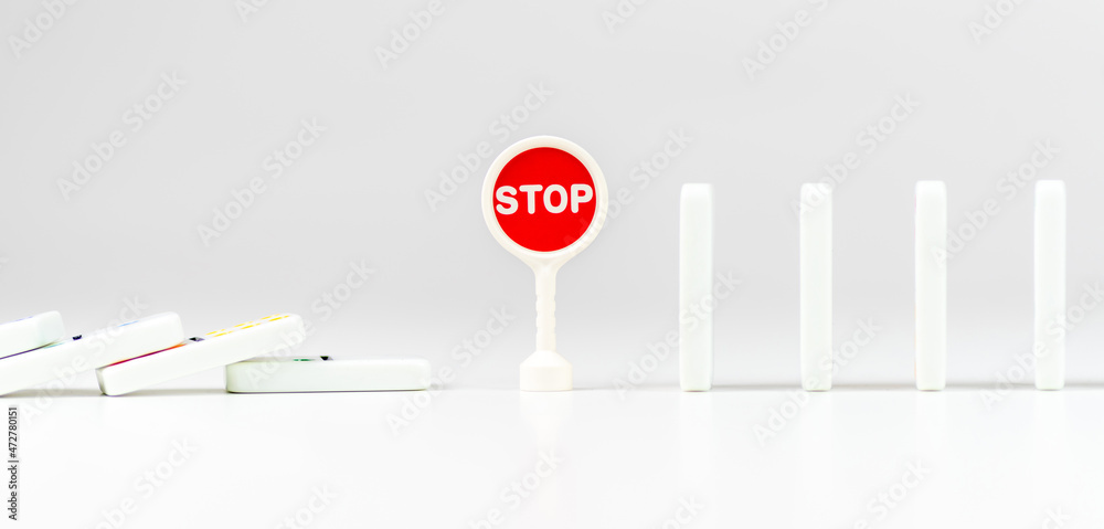 Domino effect. Chain reaction. Falling dominos pieces stopped by sign ...